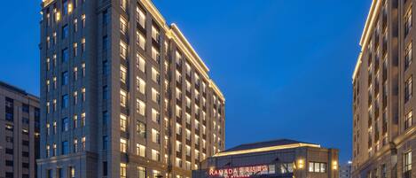 Um hotel com vários andares e um destaque para a placa