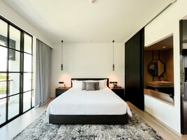 Quarto moderno com cama grande, mesas de cabeceira, armário embutido e uma janela ampla com cortinas.