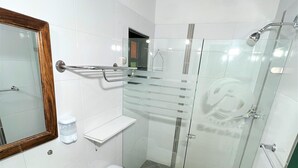 Uma casa de banho moderna com sanita, lavatório e cabine de duche envidraçada.