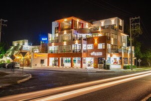 Um edifício de vários andares com diversos estabelecimentos comerciais, incluindo um bar, spa e restaurante.