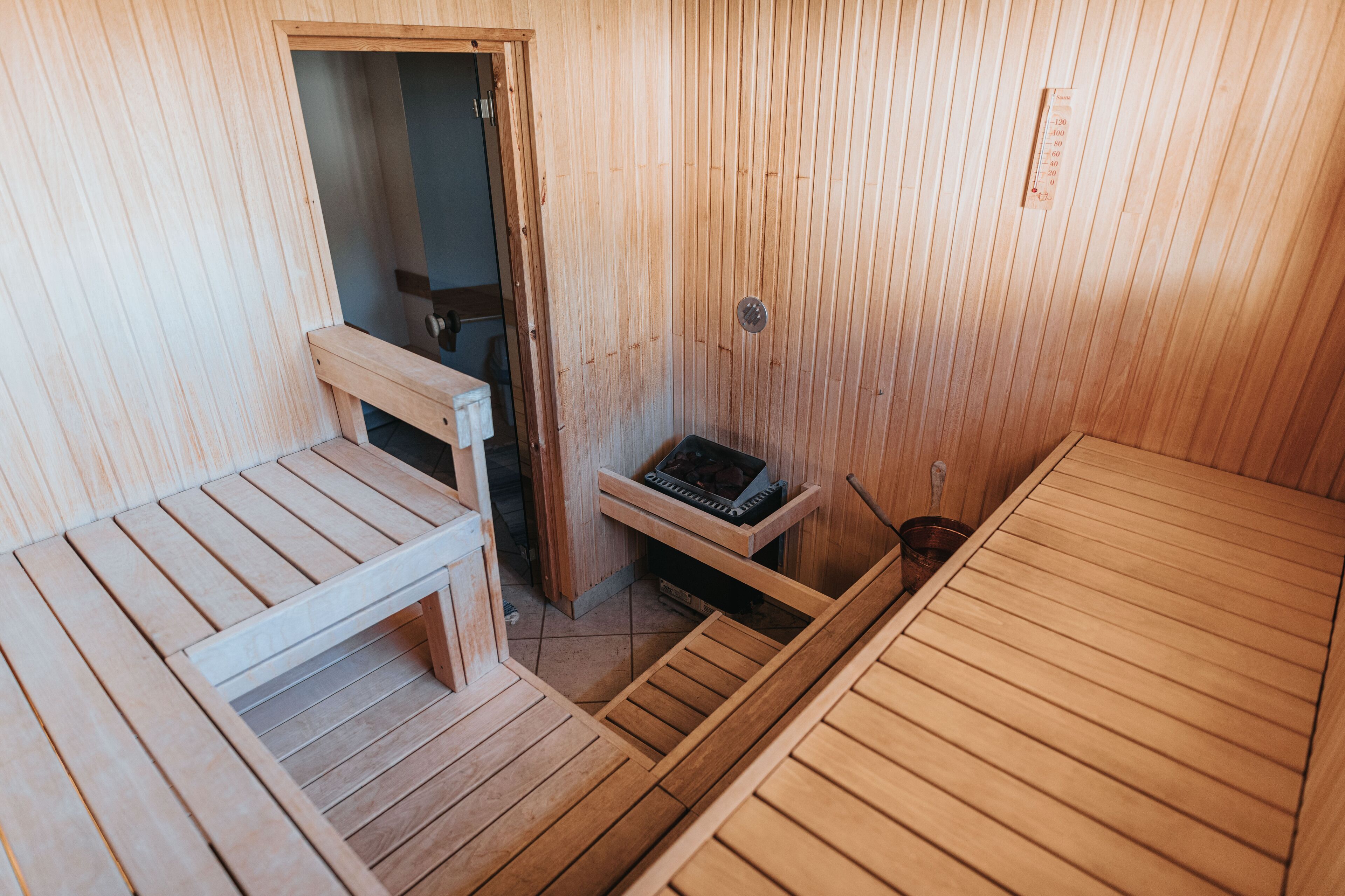 Uma sala de sauna de madeira com bancos e uma prateleira.