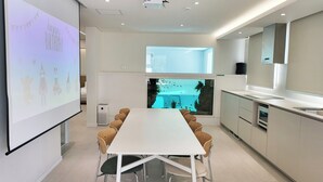 Cozinha moderna com bancada branca, forno embutido e uma janela grande.