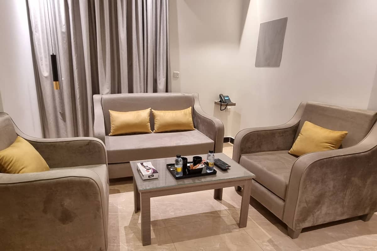 Uma sala de estar moderna com duas poltronas, um sofá e uma mesa de centro.