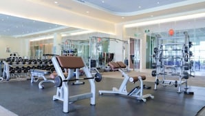 Uma academia moderna com diversos equipamentos de exercícios, incluindo aparelhos de musculação e halteres.