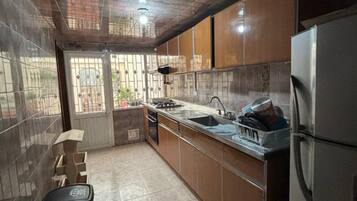 Um frigorífico, um forno, utensílios de cozinha, Produtos de limpeza