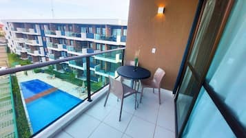 Varanda com piscina, mesa e cadeiras.