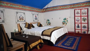 Uma yurta tradicional com uma cama, uma mesa pequena e uma cadeira.