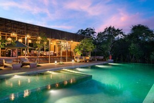 Um hotel moderno com piscina, área de estar ao ar livre e um pátio bem iluminado.