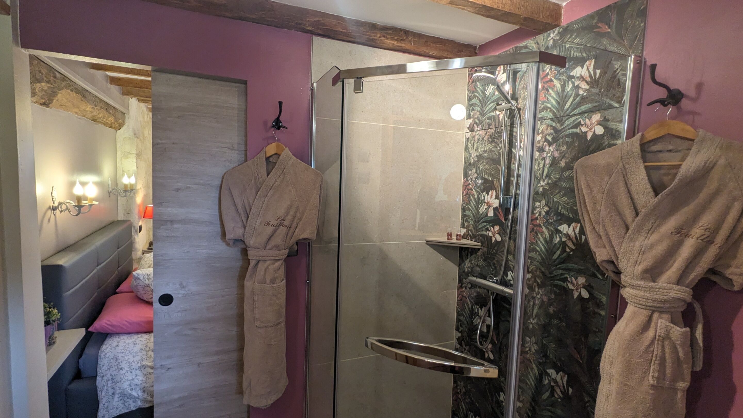 Casa de banho com chuveiro, duas toalhas, uma cama e uma toucador com espelho.