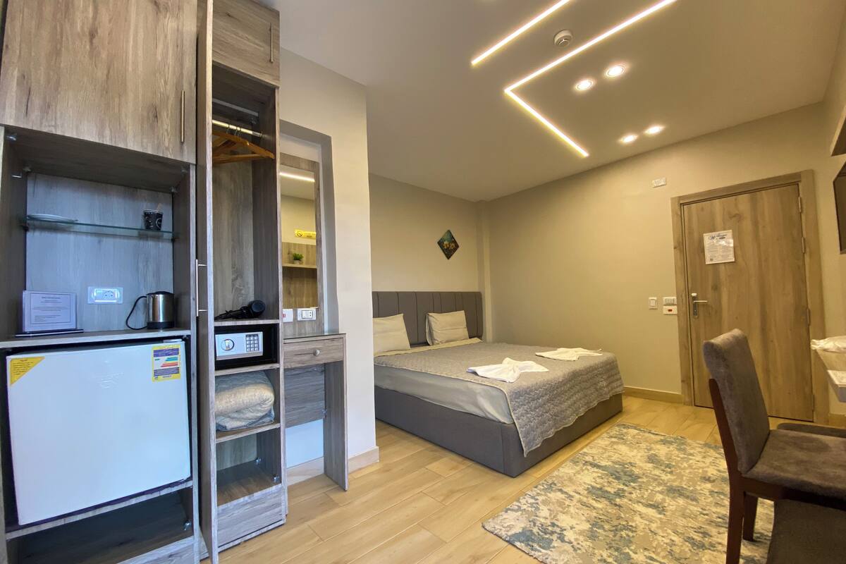 Um quarto moderno com uma cama, um guarda-roupa e uma escrivaninha.