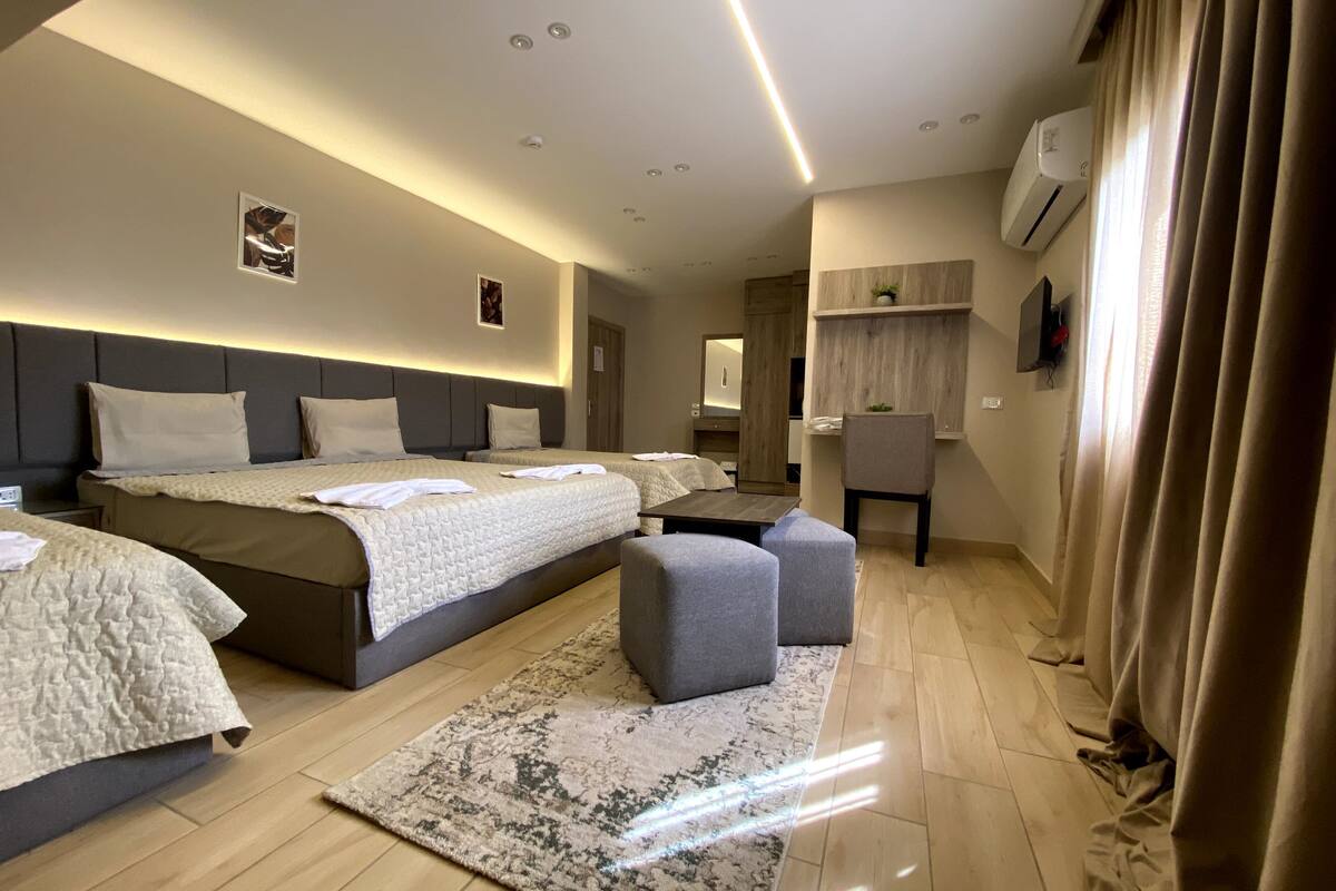 Quarto de hotel moderno com uma cama grande, uma escrivaninha e uma cadeira.