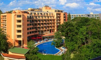 Um hotel com vários andares, piscina e vegetação exuberante.