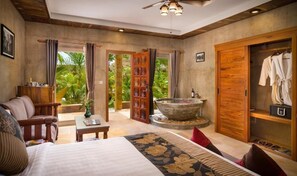Quarto com cama grande, guarda-roupa de madeira, banheira e vista para o exterior.
