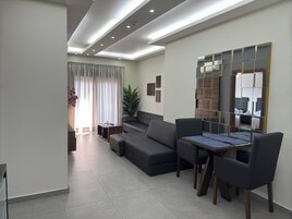 Suite Júnior, várias camas, varanda, Vista para a cidade | Sala de estar | Smart TV de 45 polegadas com canais digitais 