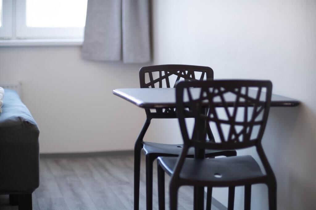 Um quarto com uma cama, uma mesa e duas cadeiras.