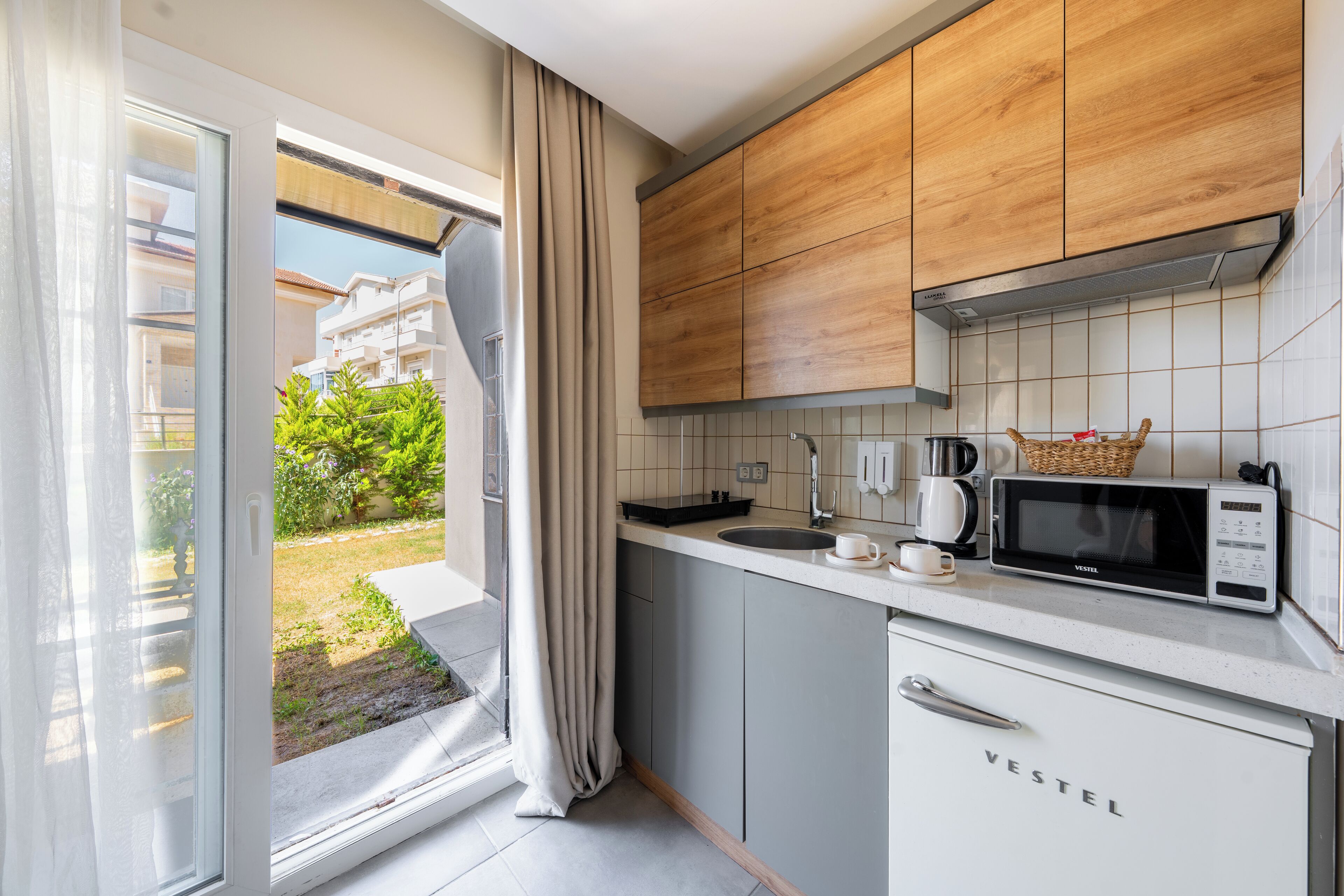 Apartamento básico, 2 camas de casal, cozinha, vista para o jardim | Cozinha privada | Frigobar, cafeteira/chaleira, chaleira elétrica, cadeirão de bebê