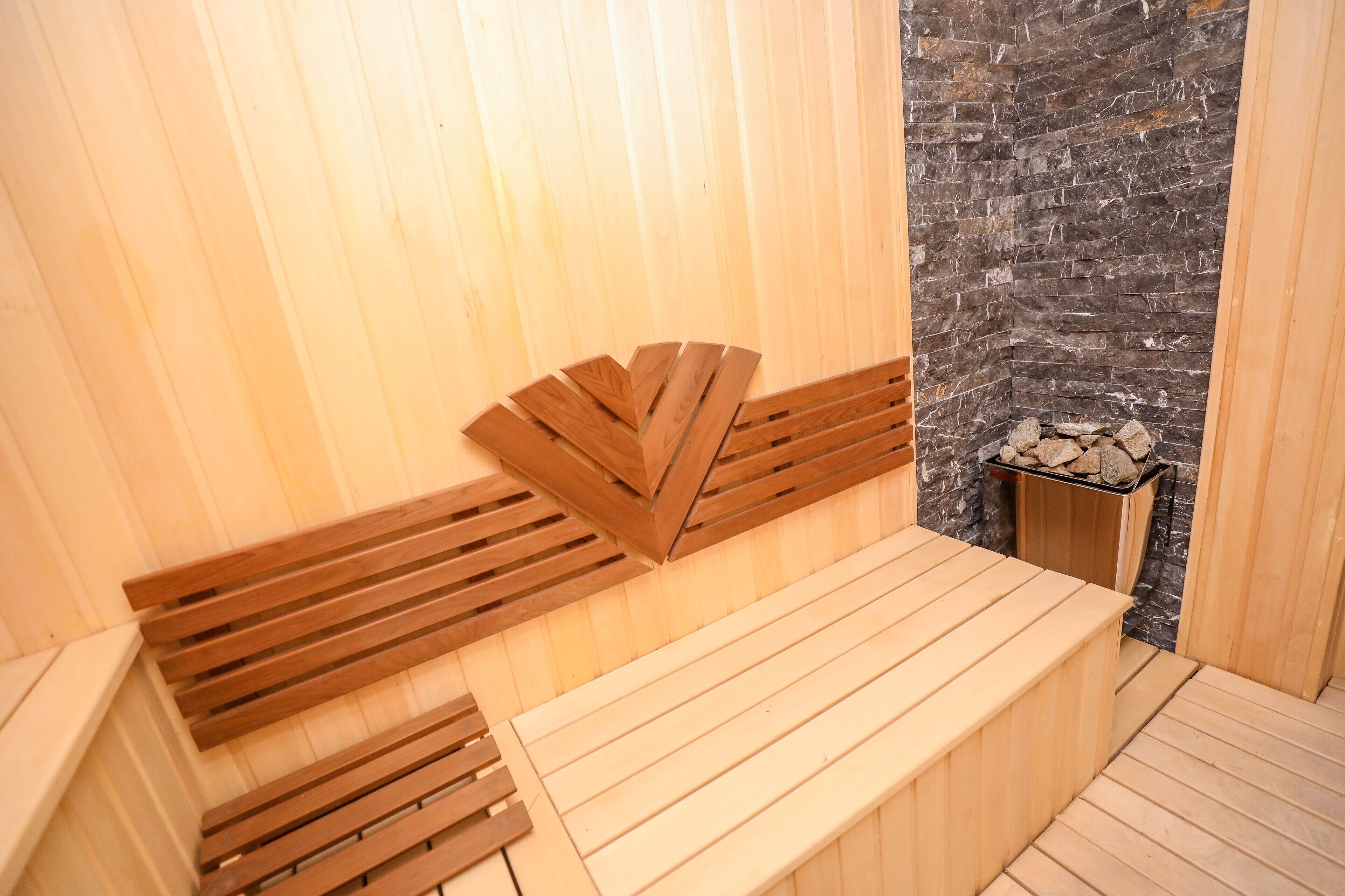 Uma sauna com bancos de madeira e parede de pedra.