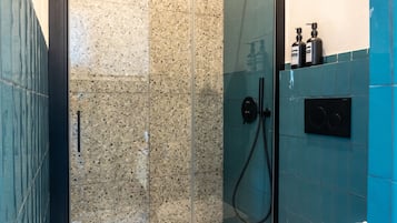 Quarto quádruplo conforto | Banheiro | Chuveiro, chuveiro com efeito de chuva, toalhas de banho, sabonete