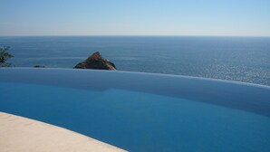 Vista clara de uma piscina com um afloramento rochoso ao fundo.
