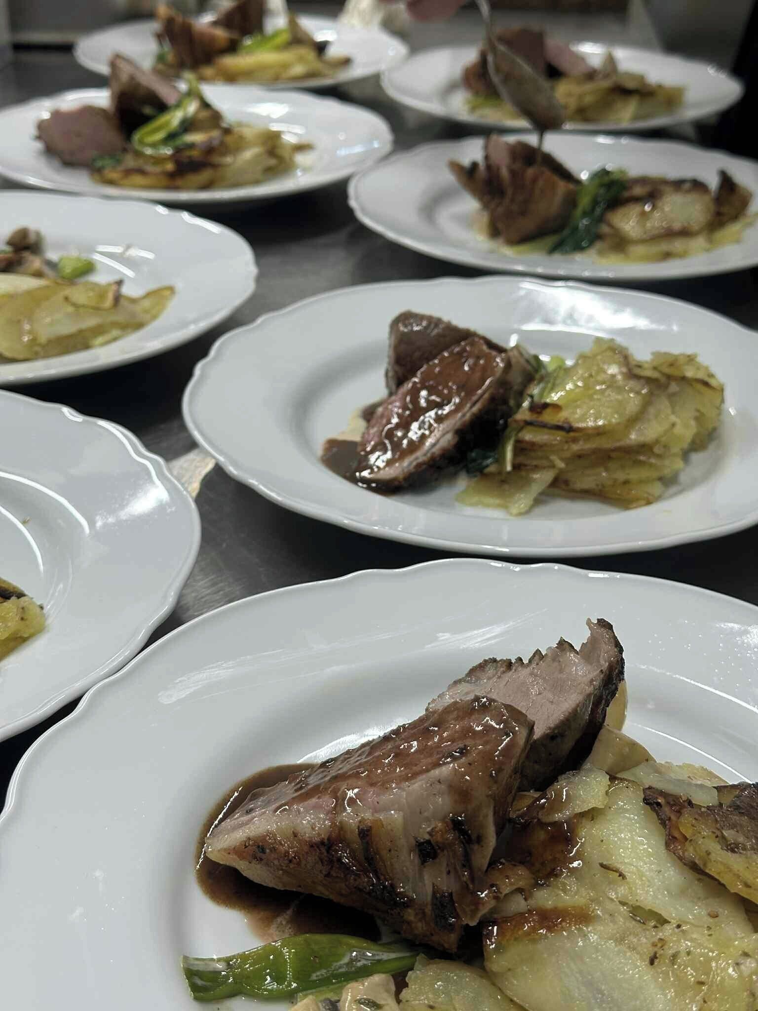 Uma mesa de jantar com vários pratos de comida, incluindo carne e legumes.