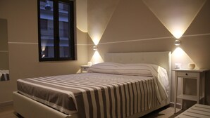 Um quarto bem arrumado com uma cama, mesas de cabeceira e uma janela.