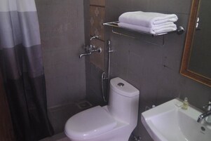 Casa de banho com sanita branca, lavatório e suporte para toalhas.