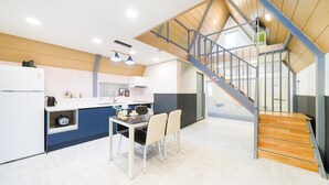 Cozinha moderna com área de refeições, escada e vista para o exterior.