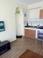 Uma cozinha moderna com armários de madeira, bancada preta e painel de azulejos.