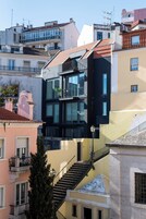Edifício de vários andares com varandas e escadaria que leva aos pisos superiores.