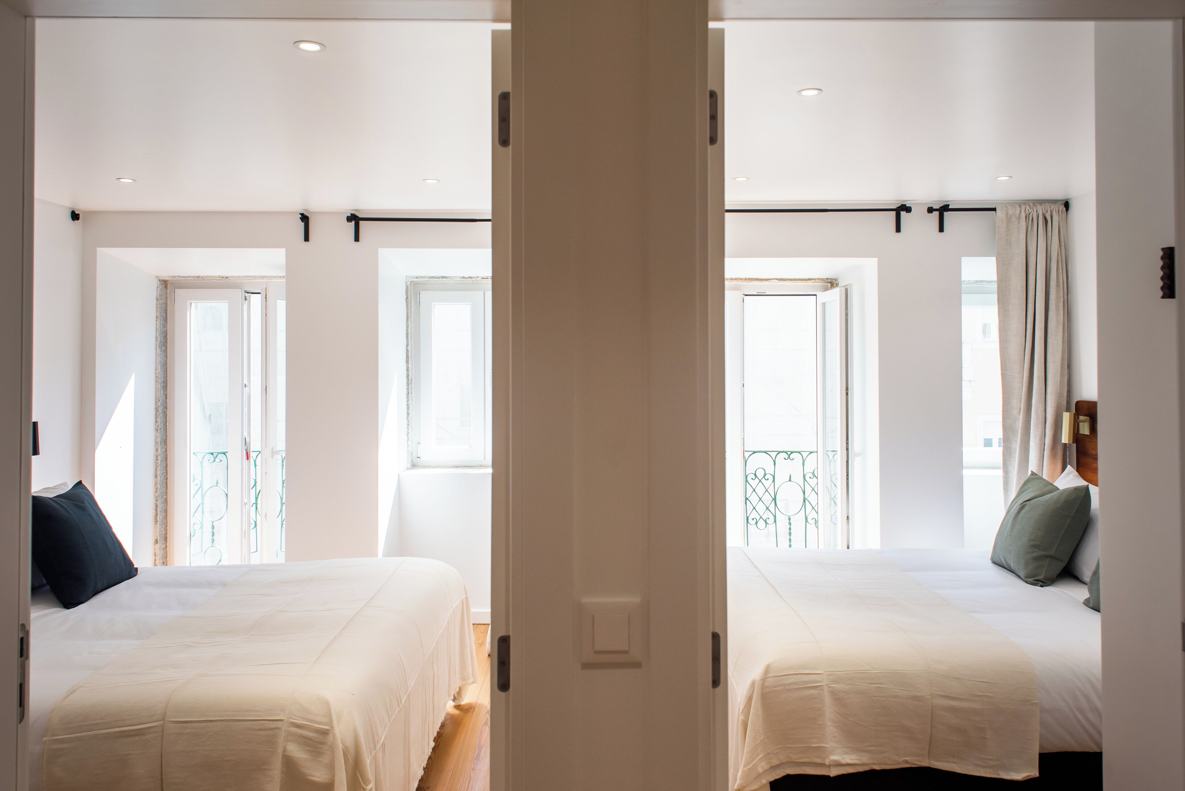 Quarto de hotel com duas camas, uma varanda e vista para o exterior.