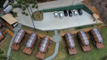 Vista aérea de uma propriedade com estacionamento, seis grandes tanques cilíndricos e um pequeno edifício com telhado inclinado.