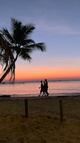 Na praia, espreguiçadeiras, guarda-sóis de praia, toalhas de praia