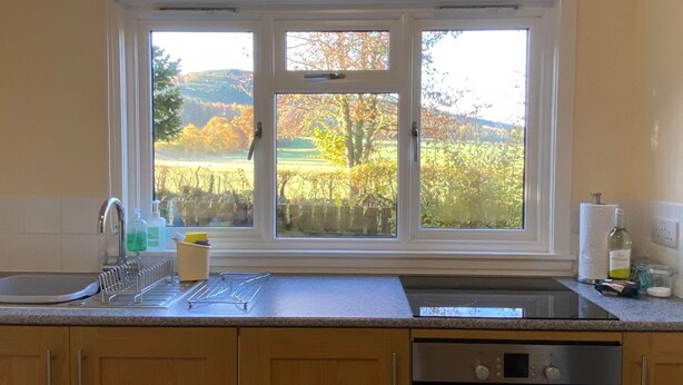Cozinha com vista para um vinhedo e colinas.