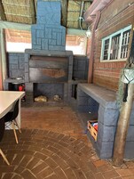 Uma cozinha de pedra com forno embutido, pia e janela com grades.