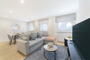 Apartamento Superior, 2 quartos | Sala de estar | TV de ecrã plano 