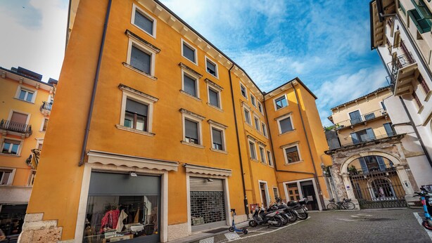 Um edifício amarelo com várias janelas e uma porta de garagem fechada.