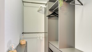 Um closet espaçoso com cabideiro, prateleiras e sapateira.