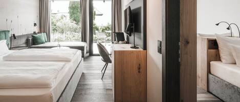 Quarto de hotel moderno com duas camas, uma mesa de trabalho e uma TV.