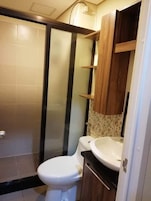 Casa de banho com sanita, lavatório e zona de duche.