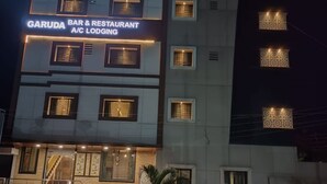 Um edifício de vários andares com uma placa para GARUDA BAR & RESTAURANT, hospedagem com ar condicionado.