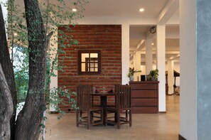 Uma sala de jantar com parede de tijolos, mesa de madeira e cadeiras.