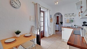 Cozinha moderna com mesa de jantar de madeira, um relógio e vista para a sala de jantar.
