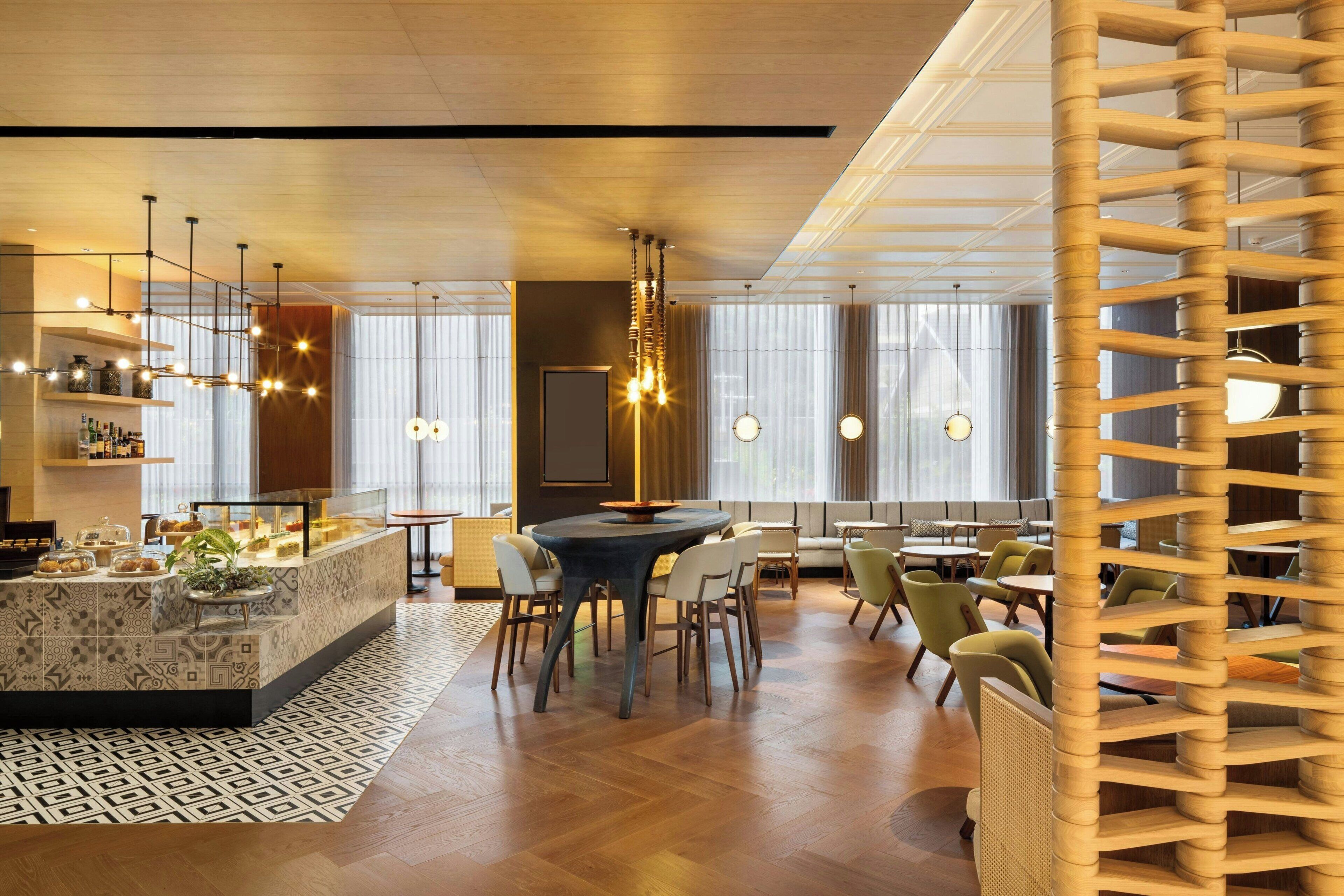Uma sala de jantar moderna com uma ilha central, diversas opções de assento e iluminação pendente.