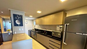 Uma cozinha moderna com eletrodomésticos de aço inoxidável, uma ilha central e design minimalista.