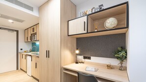 Uma cozinha moderna com armários de madeira, micro-ondas embutido e bancada com pia.