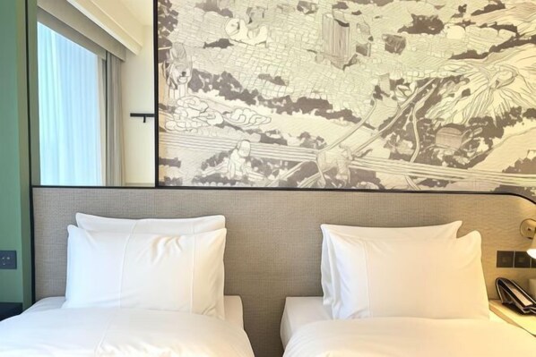Quarto de hotel com duas camas, uma janela grande e um mural decorativo na parede.