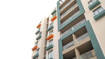 Um edifício com vários andares, varandas e janelas grandes.