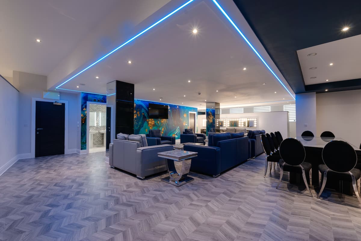 Ampla sala de estar com design moderno, apresentando um amplo sofá, uma mesa de centro e uma mesa de jantar com cadeiras.