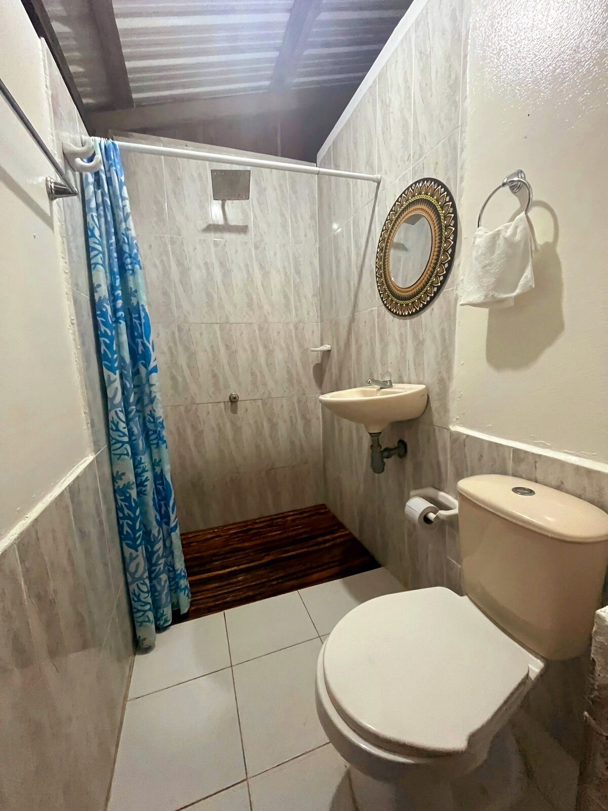 Casa de banho com sanita, lavatório e zona de duche.