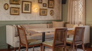 Uma área de refeições acolhedora com teto de madeira, um sofá e uma mesa com cadeiras.